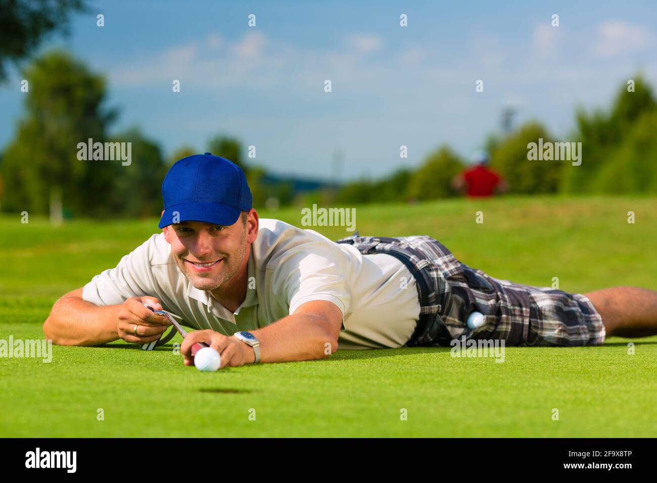 Young golf player on course putting, he aiming for his put shot Stock ...