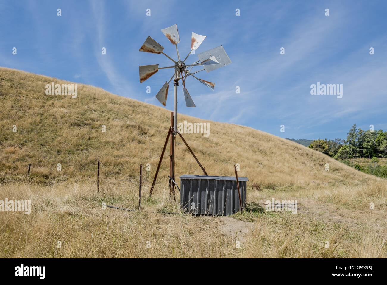 Rustic small farm windmill used for pumping water in a rural setting ...