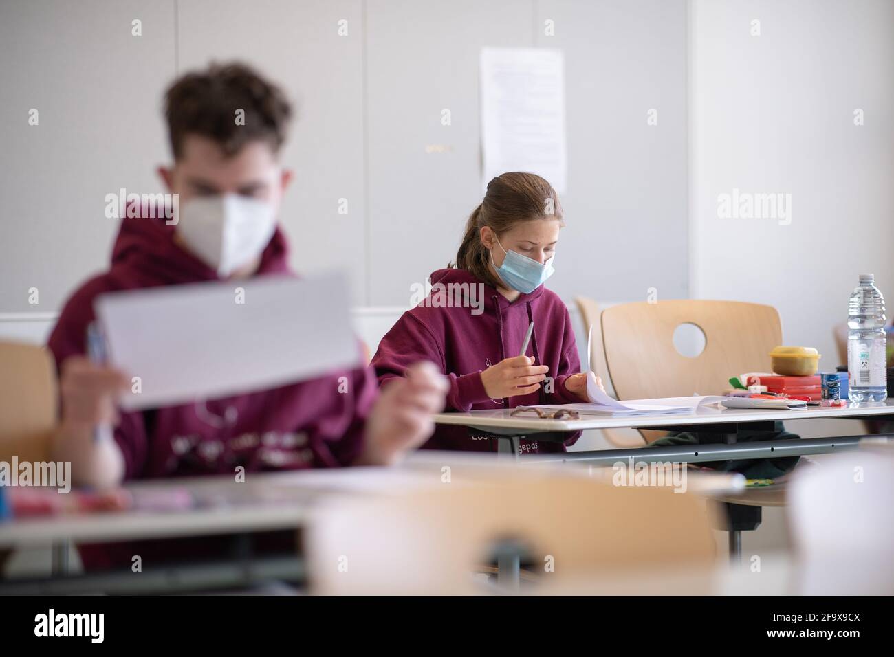 21 April 2021, Hessen, Groß-Gerau: Students wearing medical masks read ...