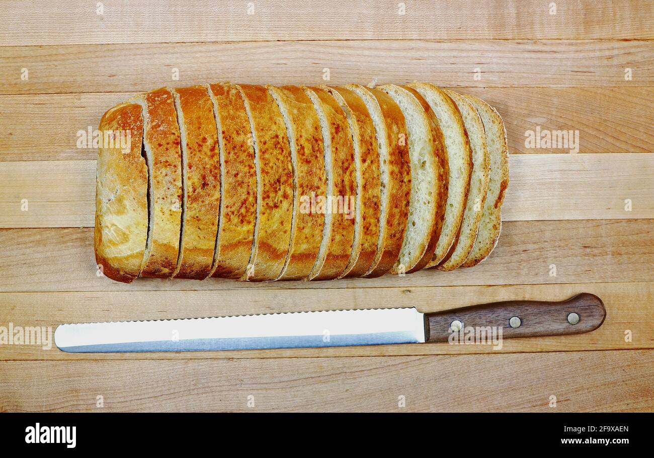 Top view of sliced bread with bread knife serrated edge. On wooden ...