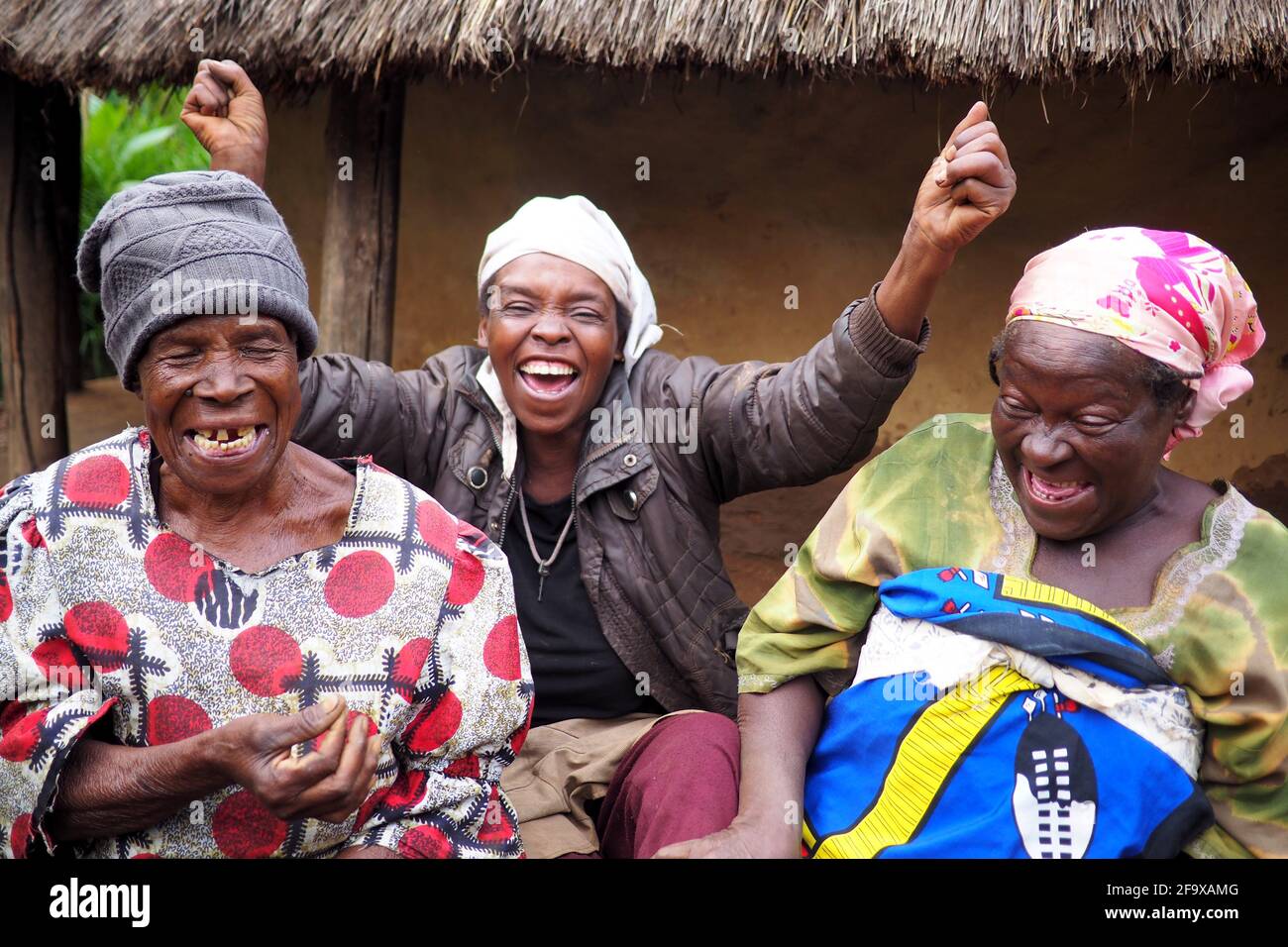 Rural African women laughing outside their hut Stock Photo - Alamy