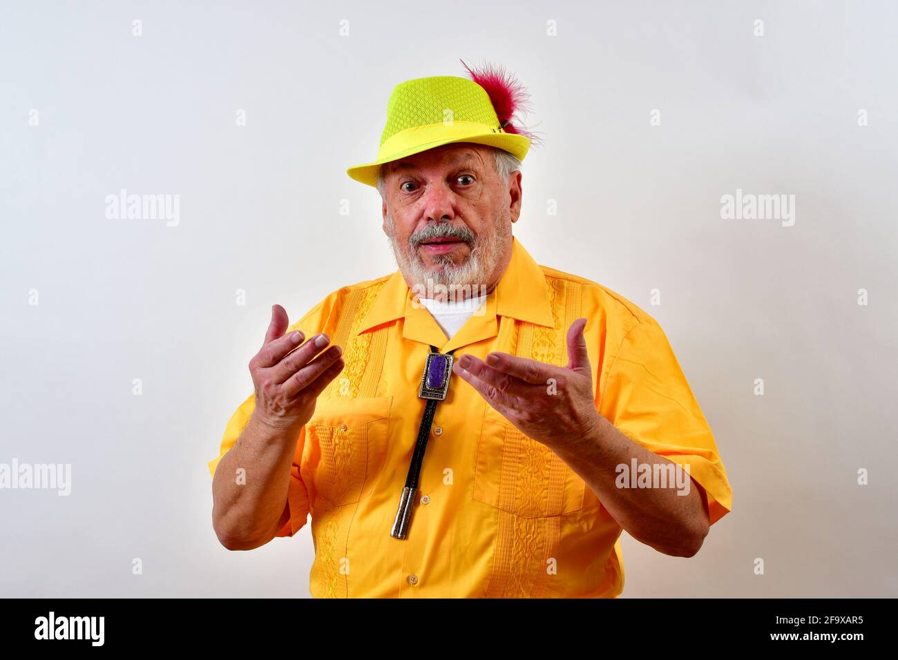 Senior male in a cute yellow outfit with a questioning pose in front of ...
