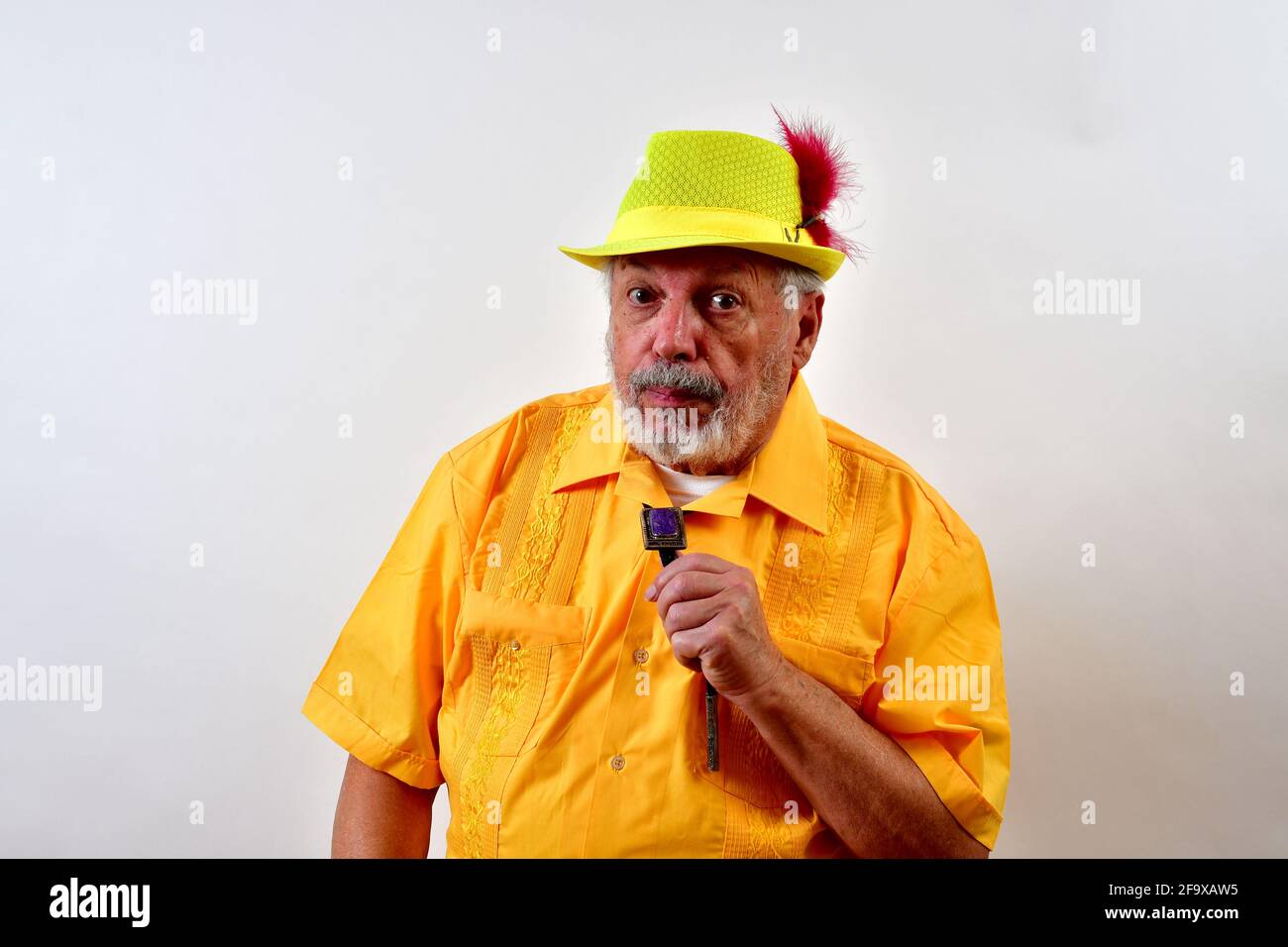 Senior male in a cute yellow outfit with an attentive pose in front of ...