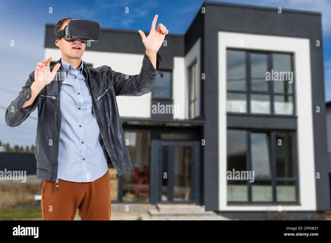 Cheerful man in virtual glasses in front of new house Stock Photo - Alamy