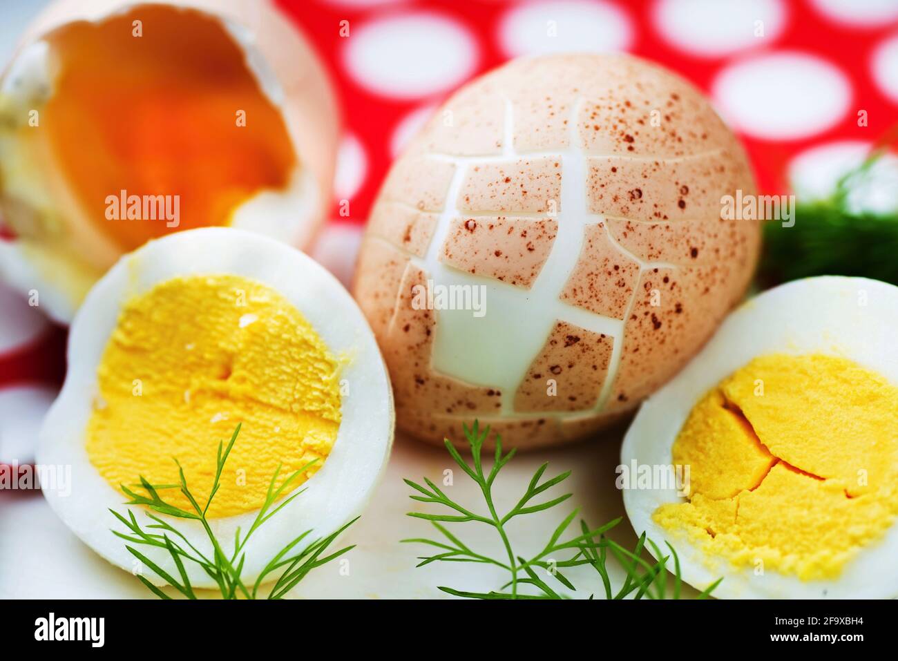 Hard boiled eggs, one with speckled cracked shell and sliced Stock ...
