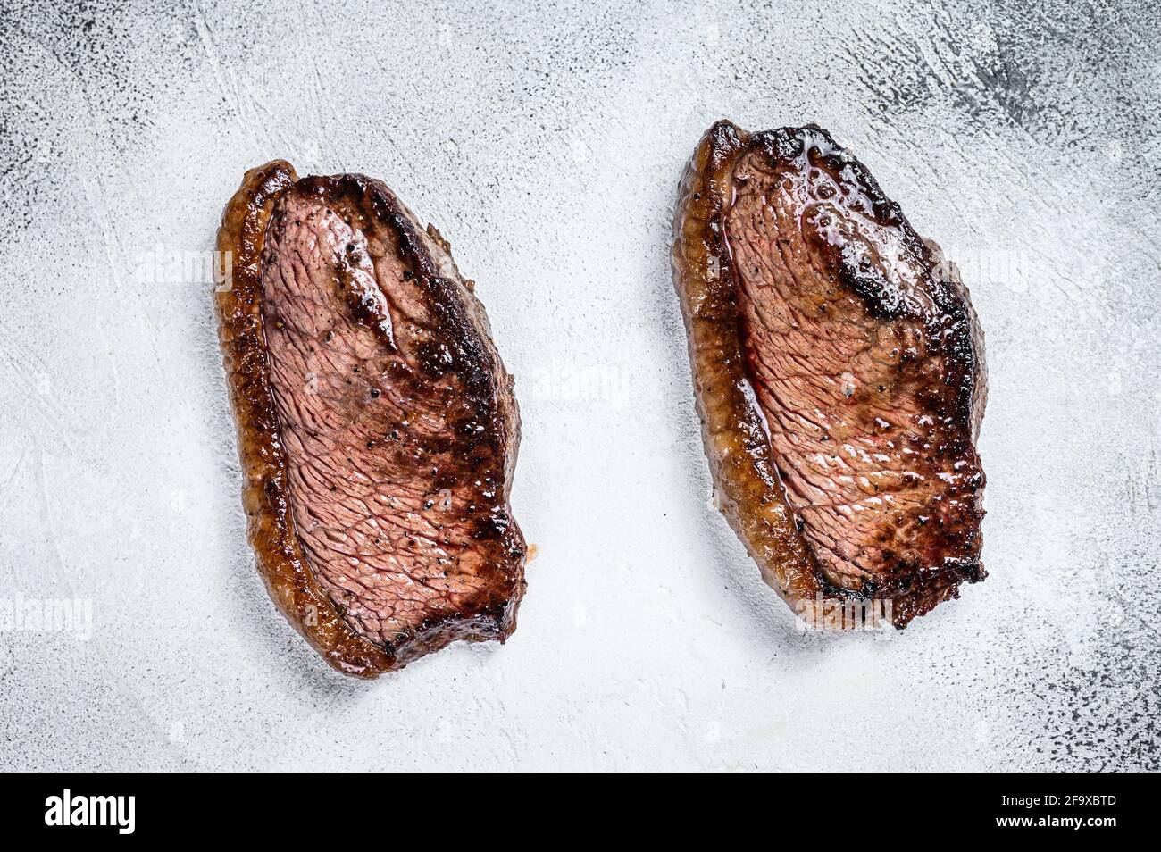 Grilled top sirloin cap or picanha steak. White background. Top view ...