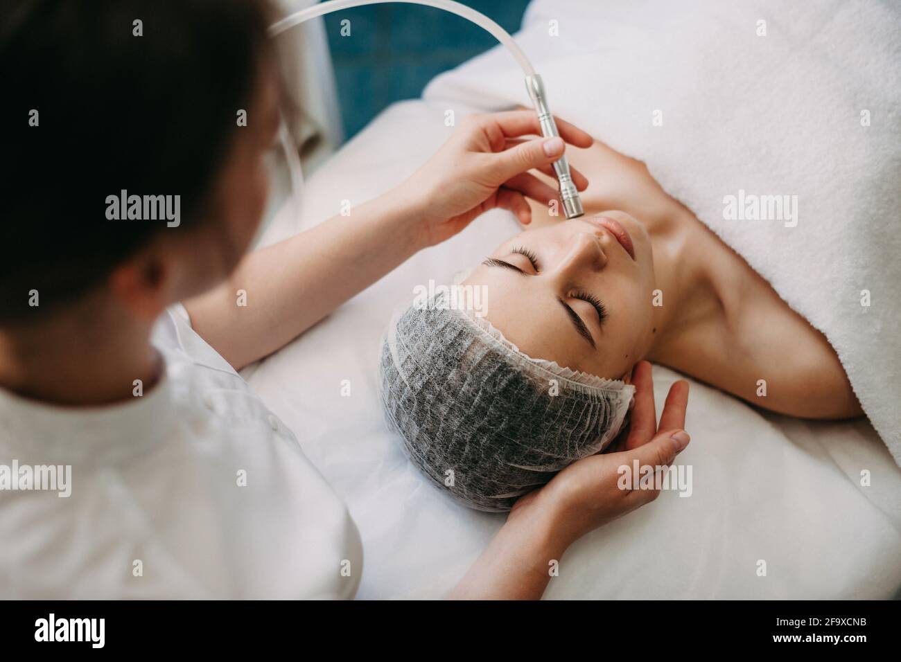 Upper view photo of a caucasian spa worker cleaning clients face with ...