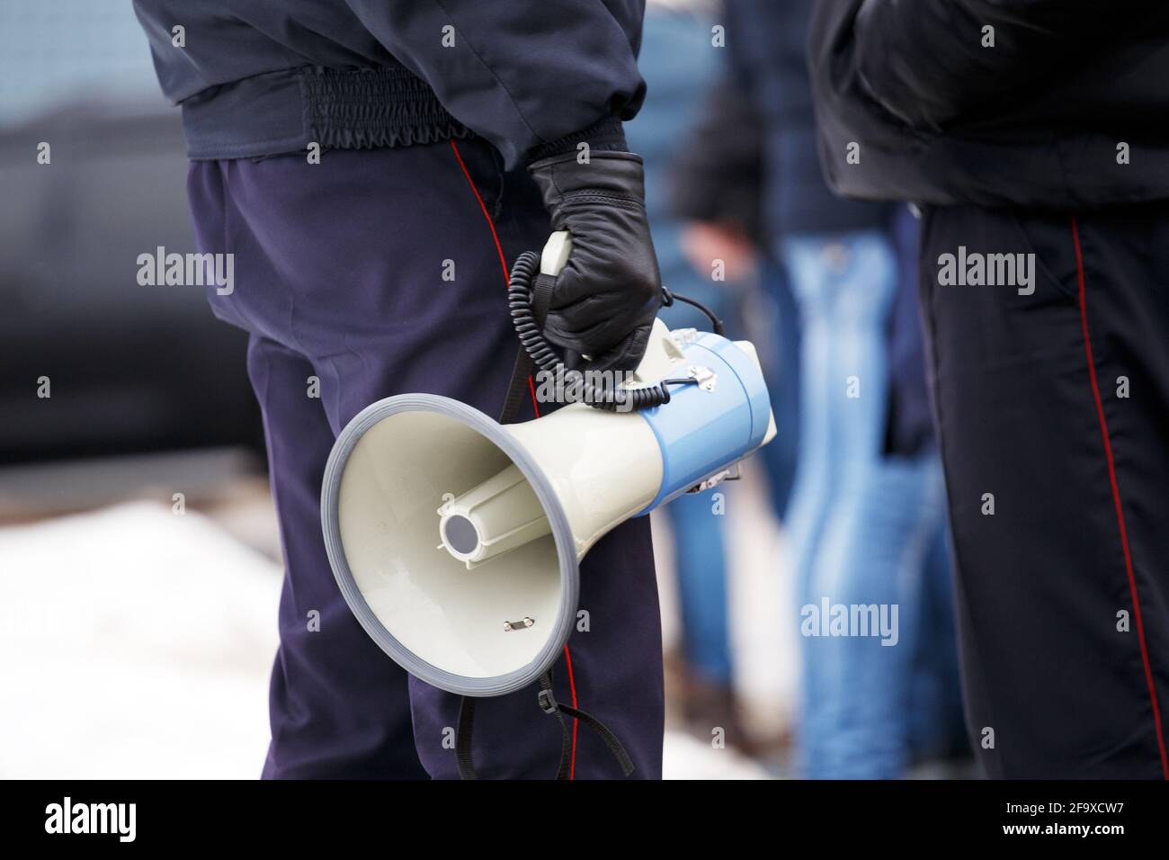 police officer holding loudspeaker megaphone at daylight, close-up with ...