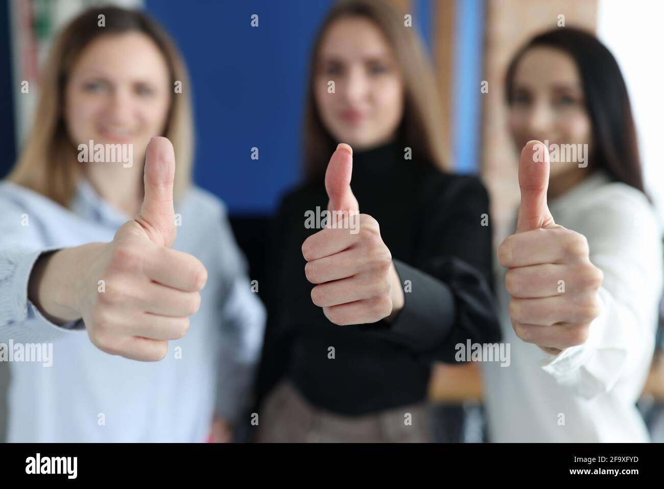 Three businesswoman are showing thumbs up gesture Stock Photo - Alamy
