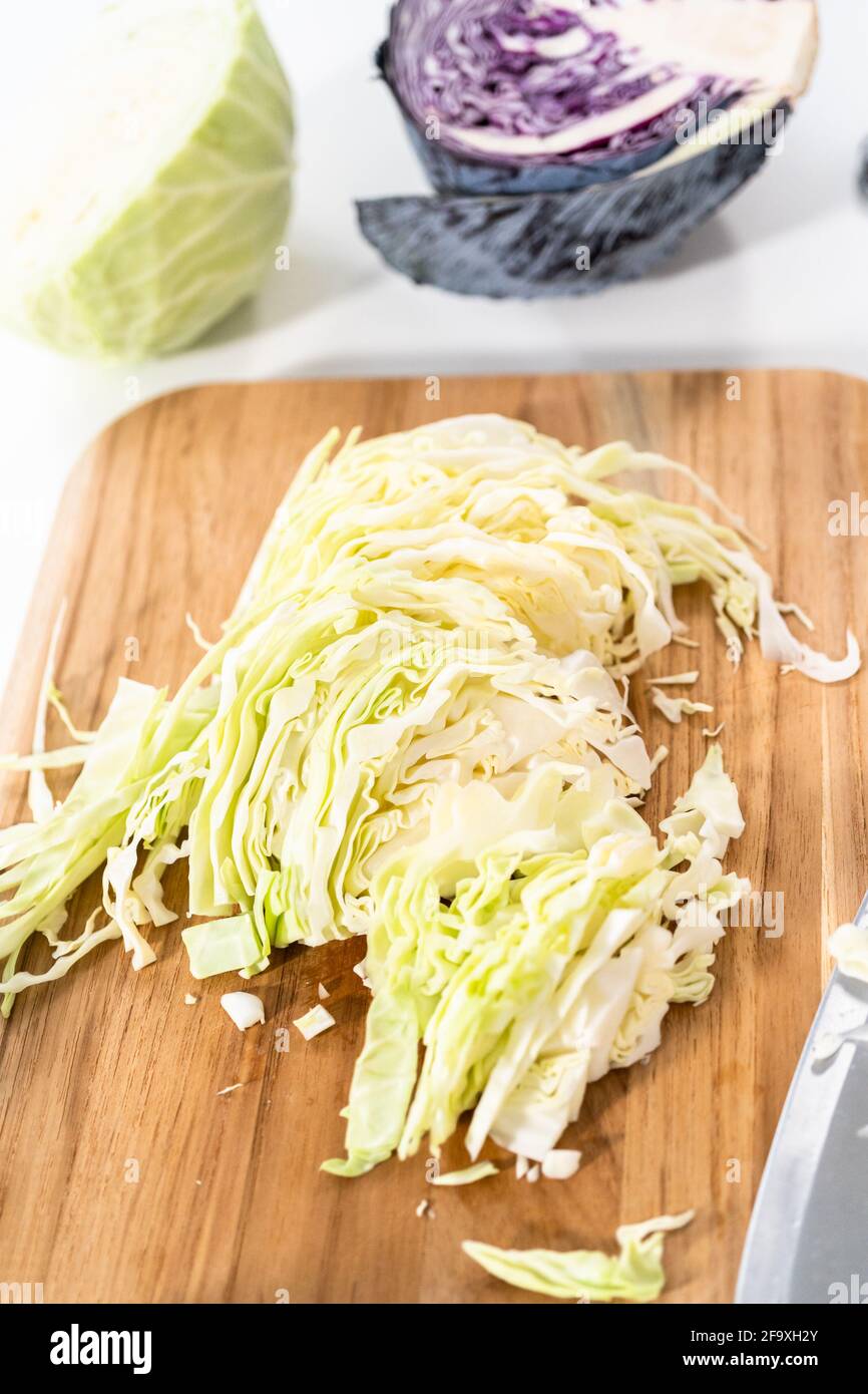 Shredding green cabbage on a wood cutting board Stock Photo - Alamy