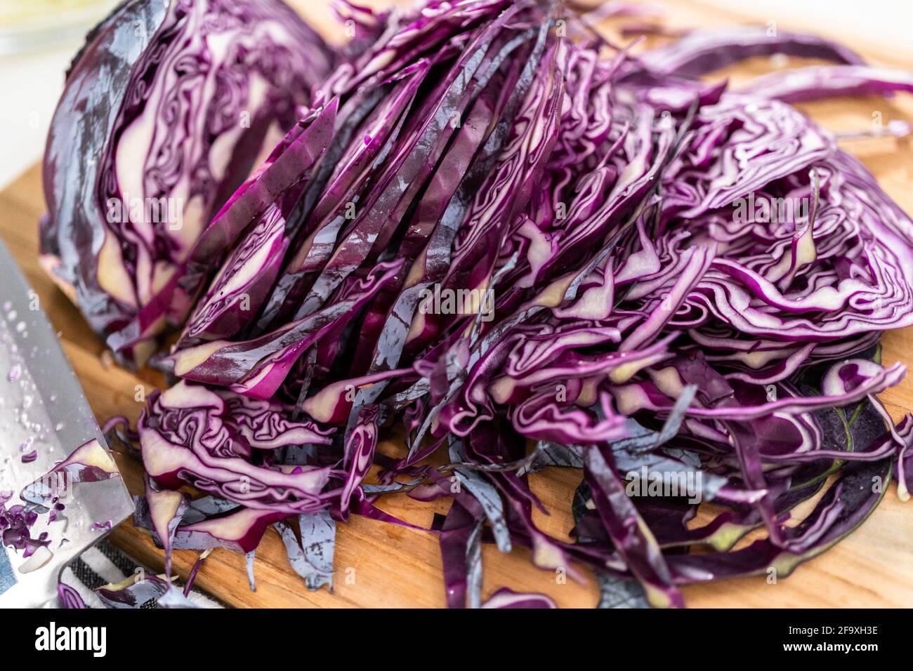 Shredding red cabbage on a wood cutting board Stock Photo - Alamy