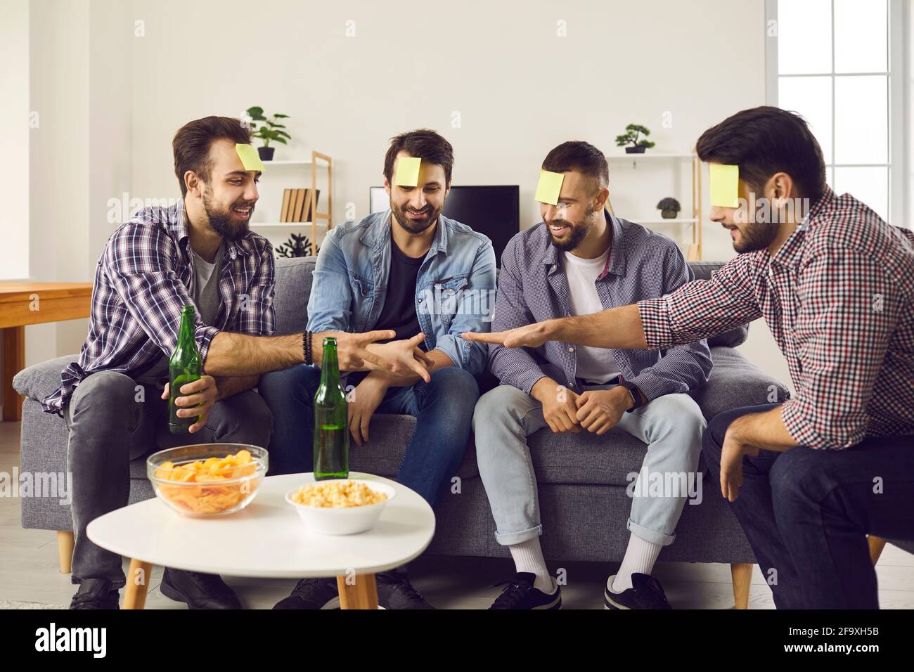 Happy friends having a party, drinking beer, playing games and enjoying ...