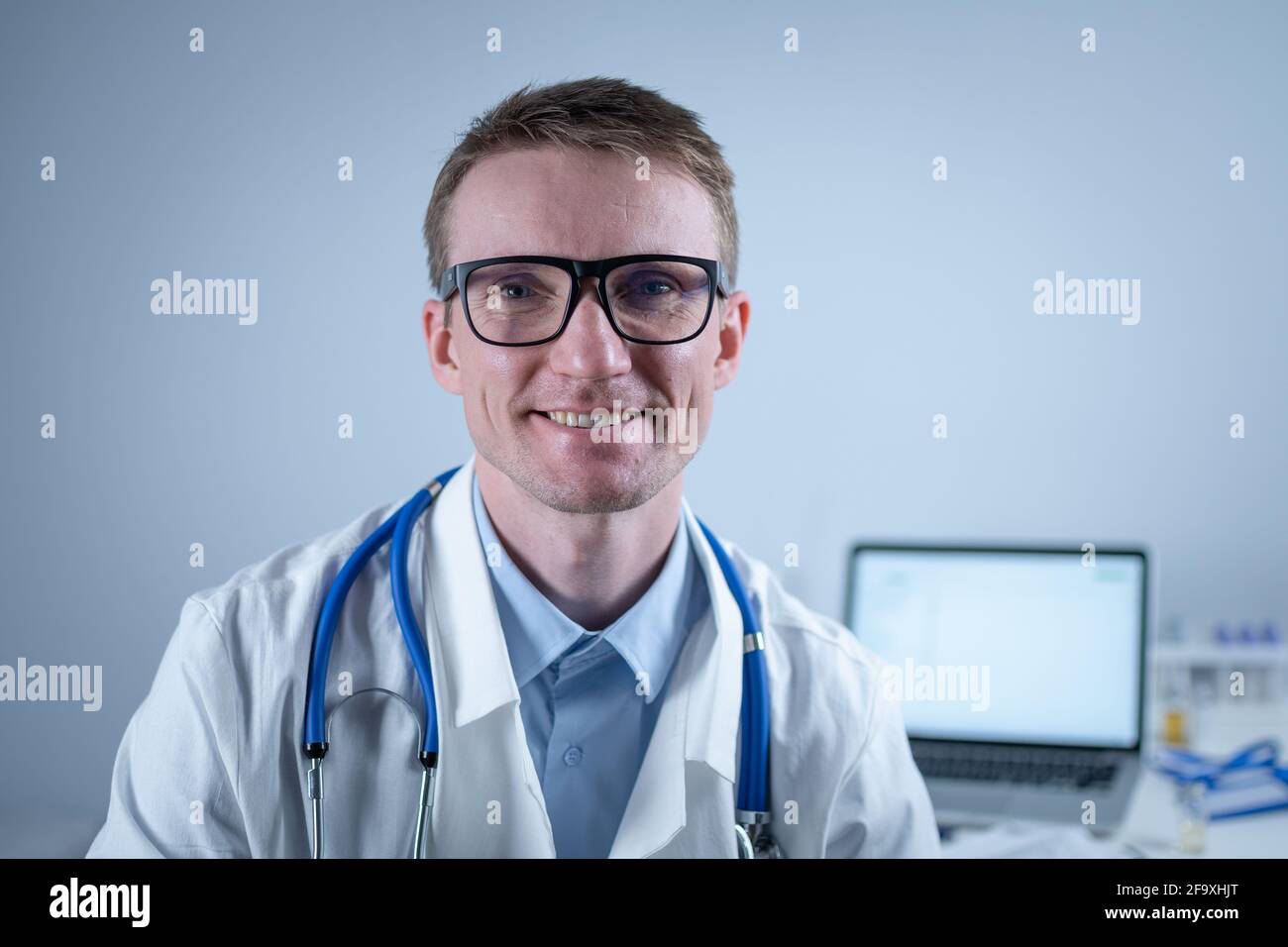 Portrait of adult handsome family doctor in medical office. Successful ...