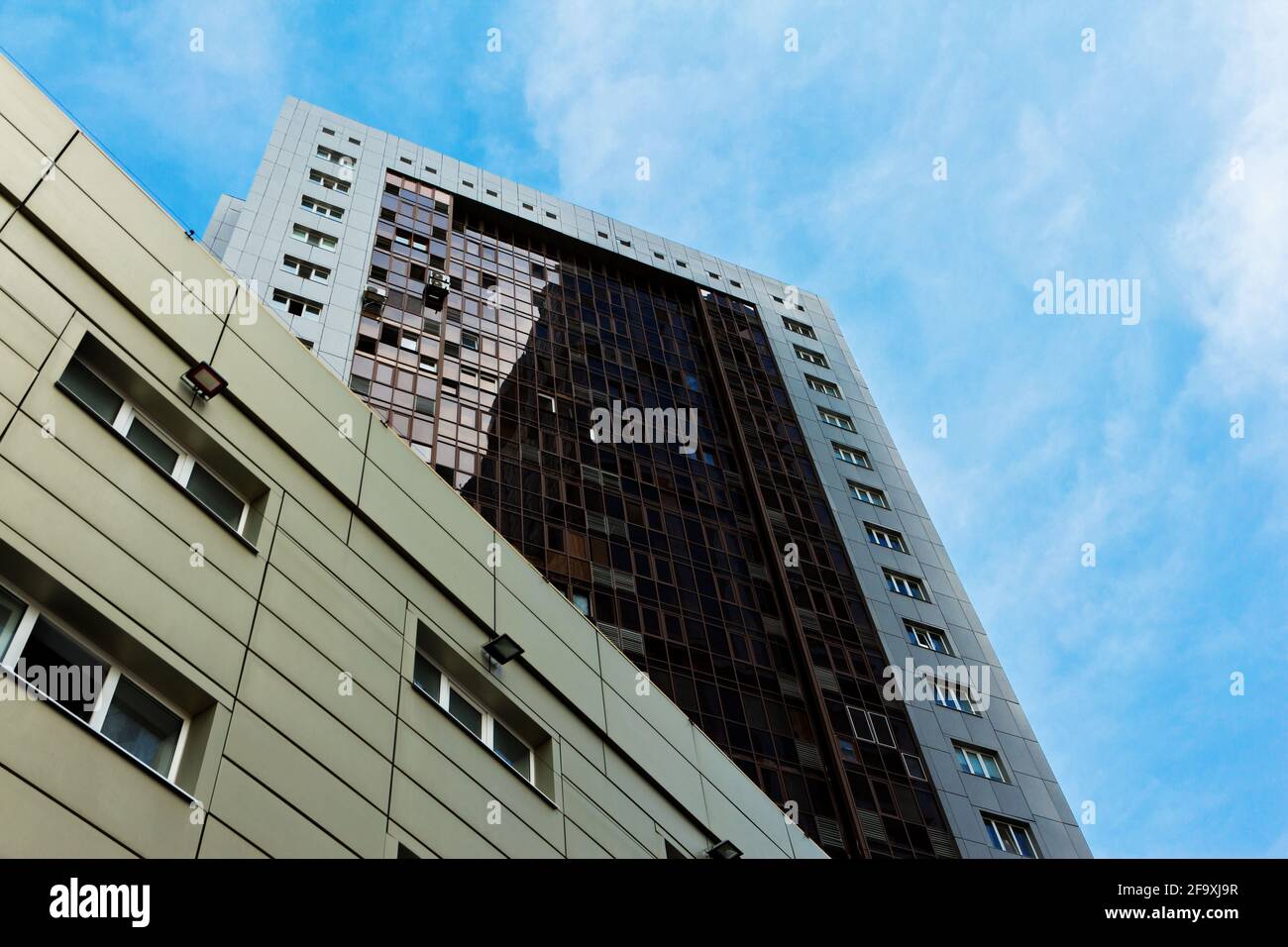 The contrast between a small house and a modern skyscraper against a ...