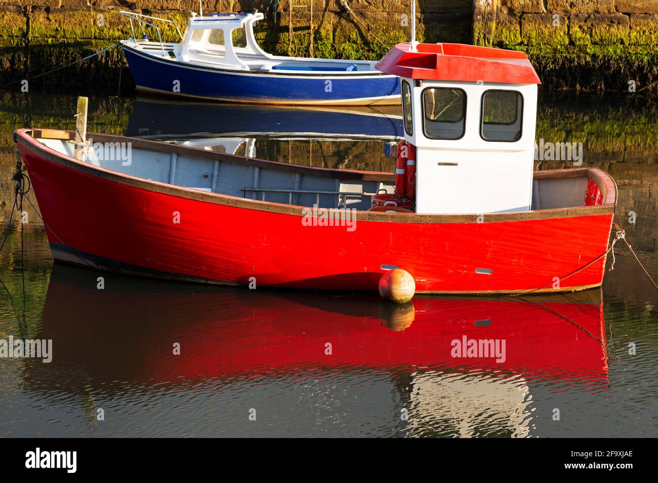 Fishing boats in harbour. The boats have red and blue hulls Stock Photo ...