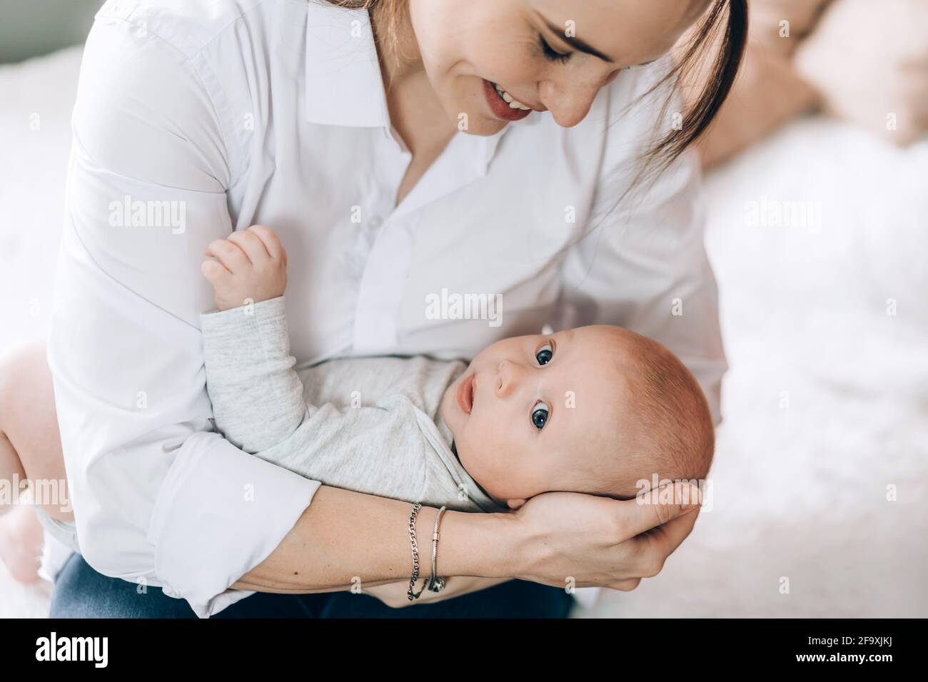 Tender mother holding her baby in her arms. Caring for the health of ...