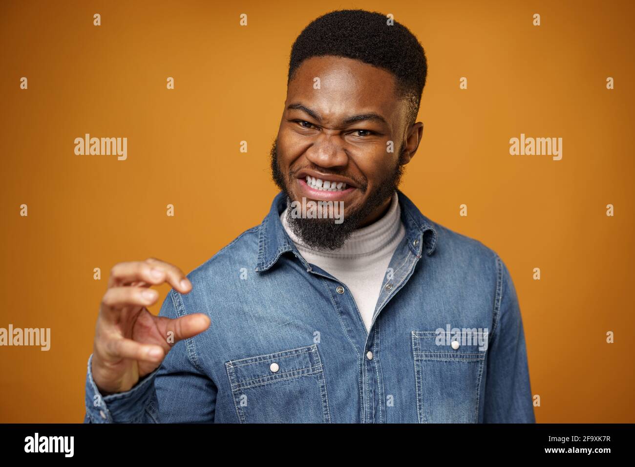 Angry upset young man clenches fist against yellow background Stock ...