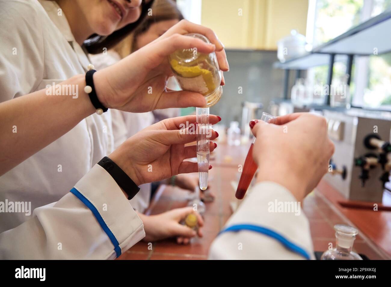Girl students conducting scientific experiment in chemistry laboratory ...