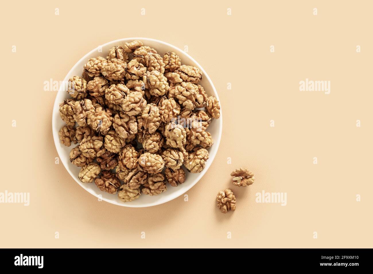 Healthy walnuts without shells in white plate on beige background with ...