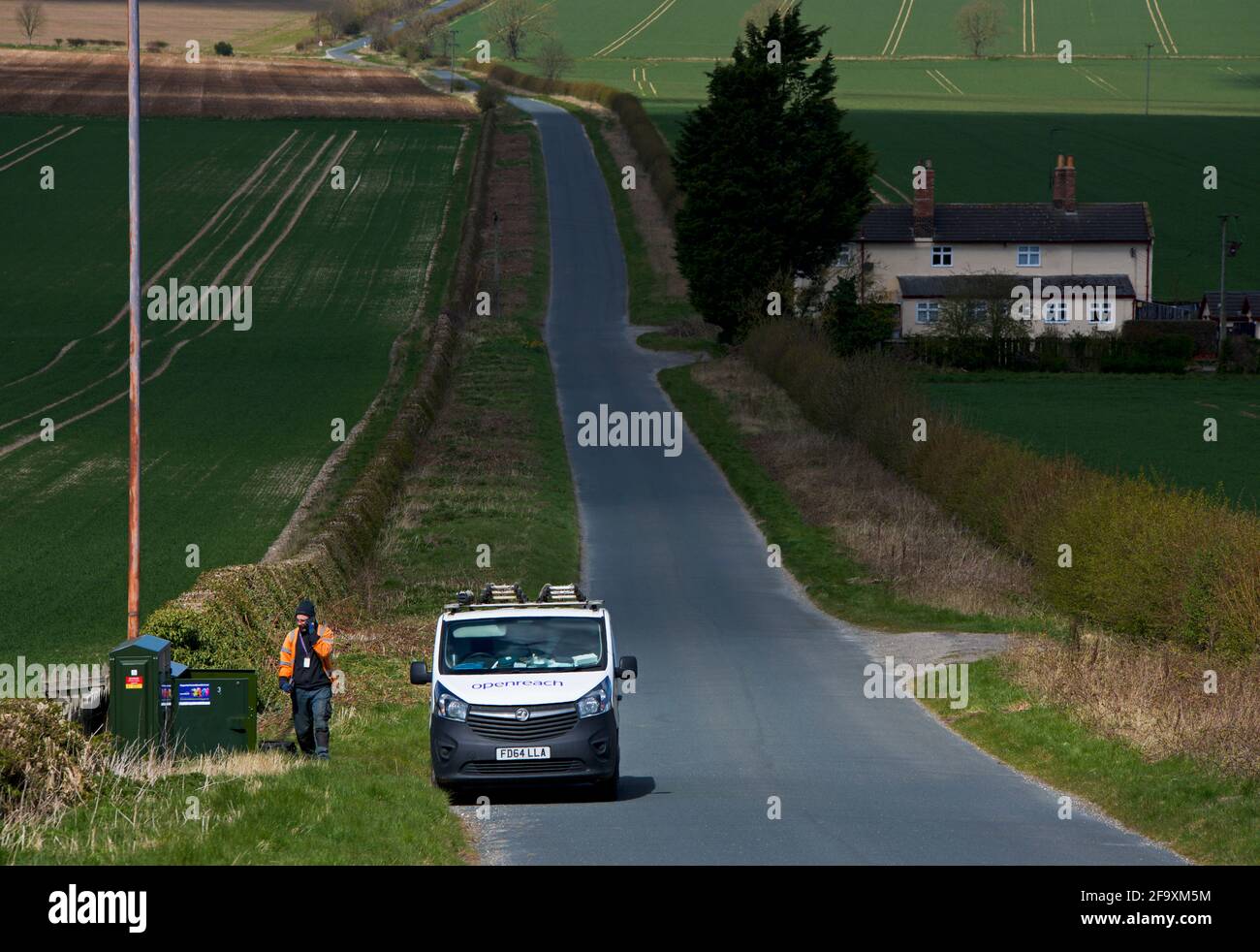 Man installing rural broadband for OpenReach, next to country road near ...