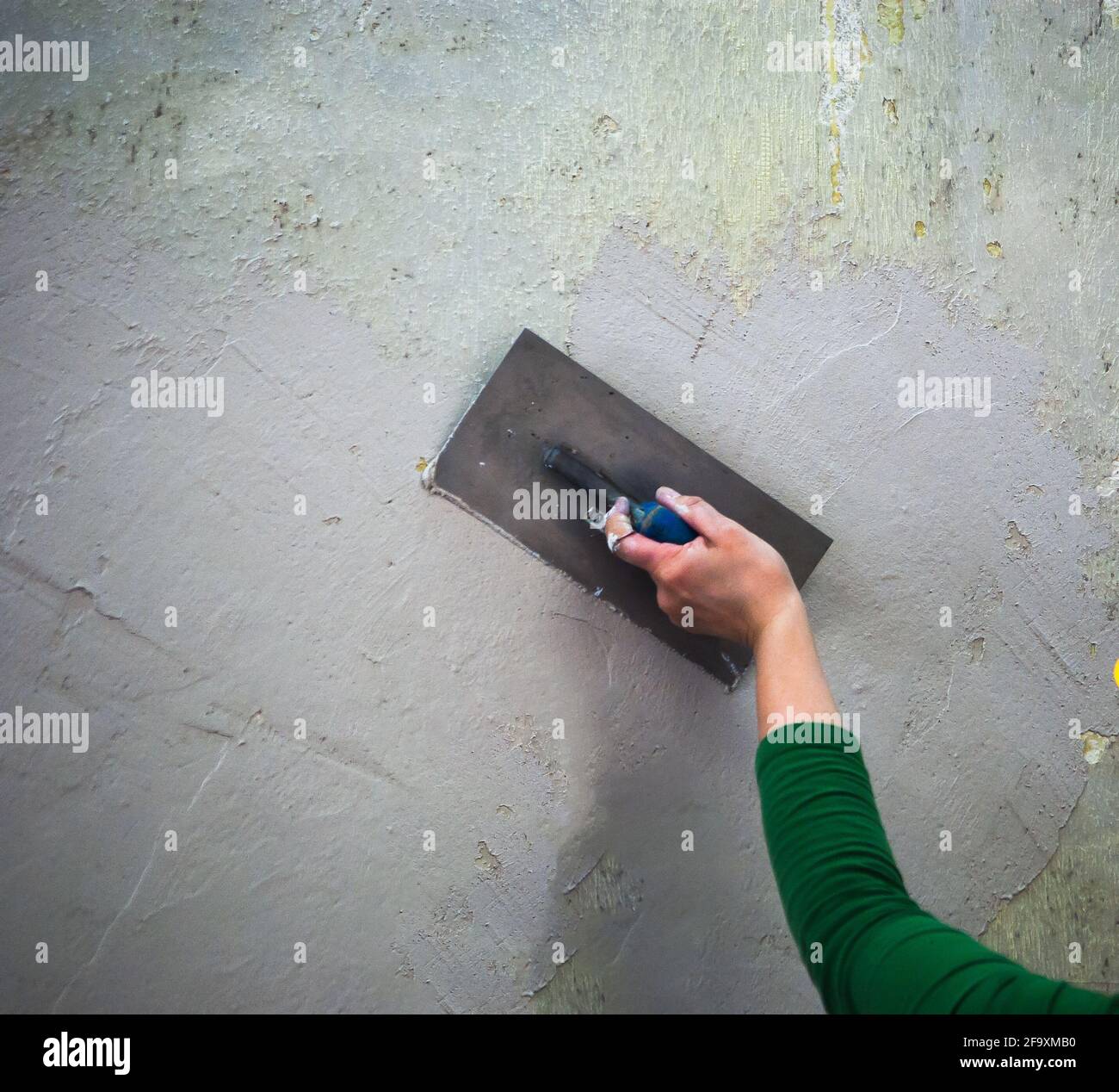 Hand of a woman plastering a wall with a trowel Stock Photo - Alamy