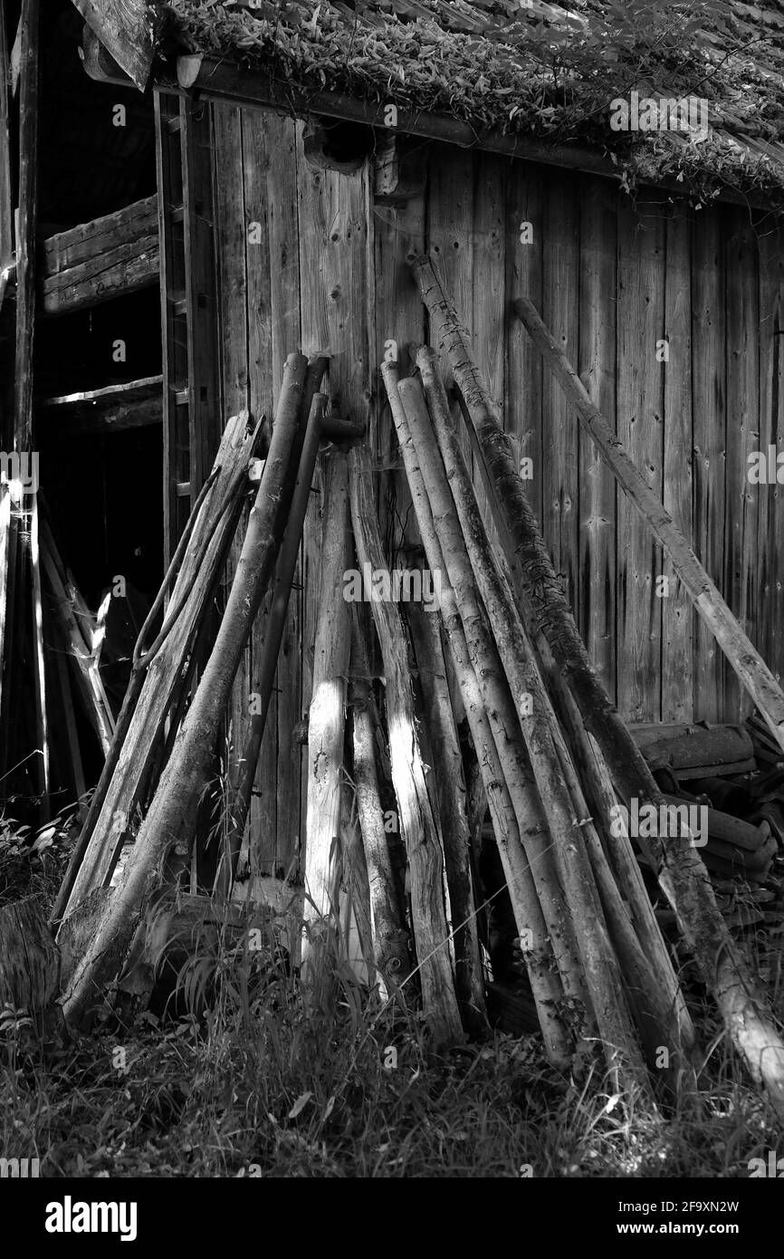 Vertical shot of logs leaned on a barn wall Stock Photo - Alamy