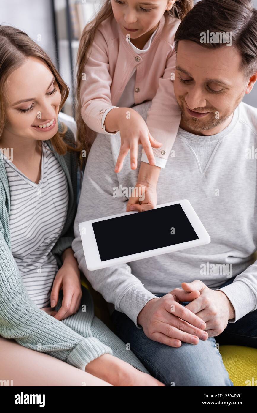 Digital tablet with blank screen in hand of child near smiling parents ...