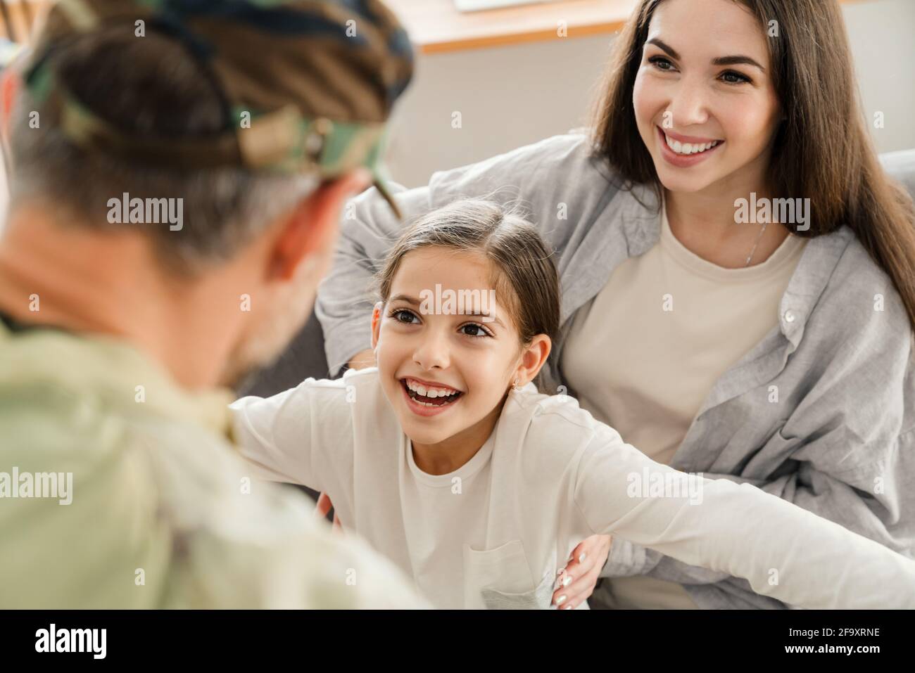 Happy kids and their mom meeting military dad in uniform indoors ...