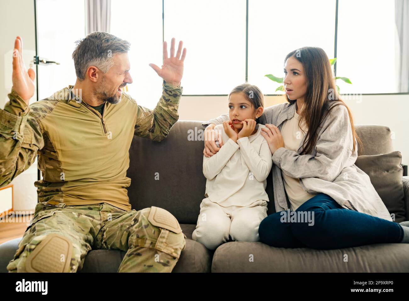 Masculine military man gesturing while talking his scared family ...