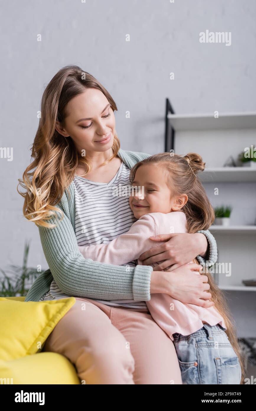 Woman embracing happy kid in living room Stock Photo - Alamy