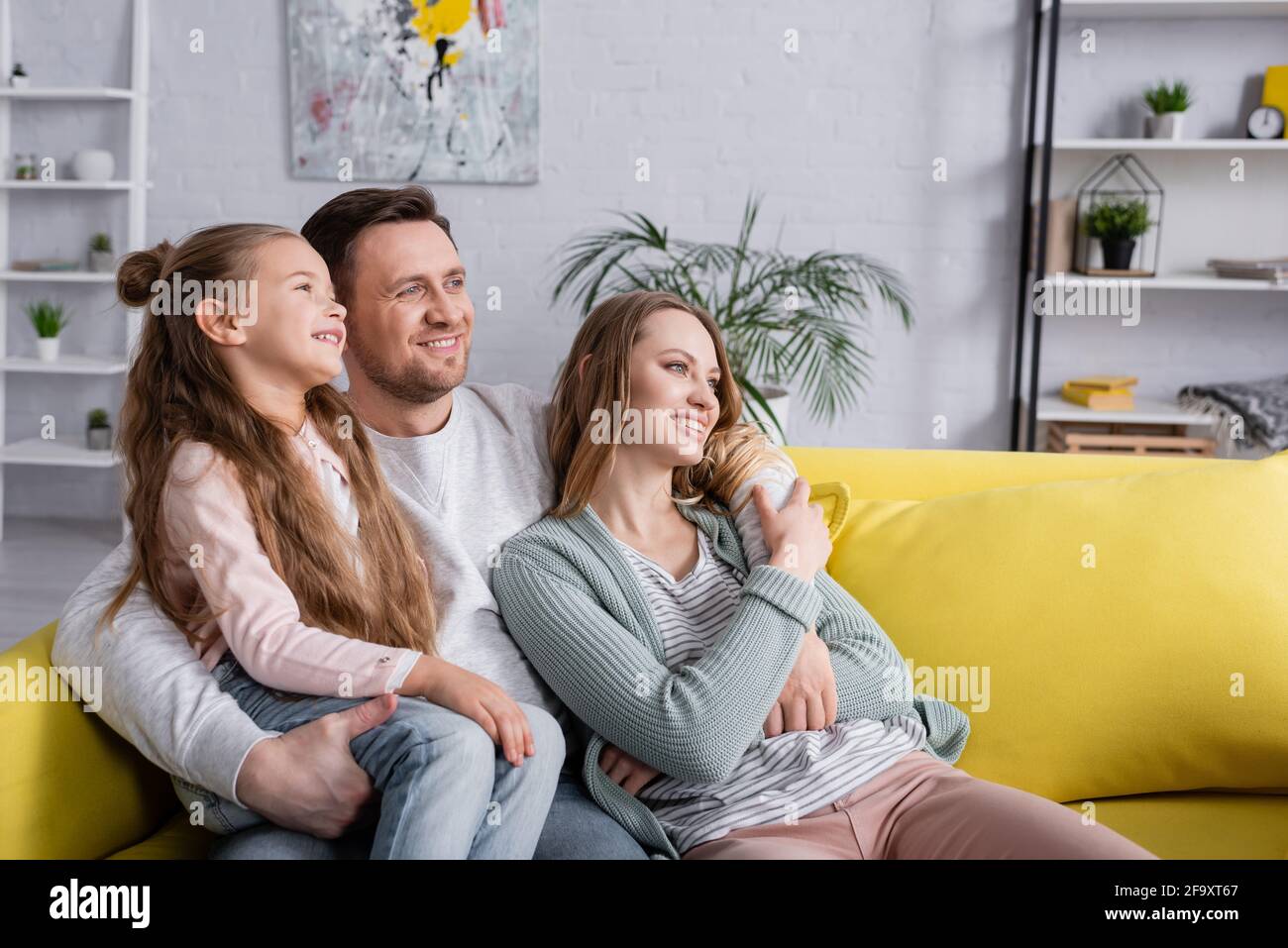 Smiling man hugging daughter and wife Stock Photo - Alamy
