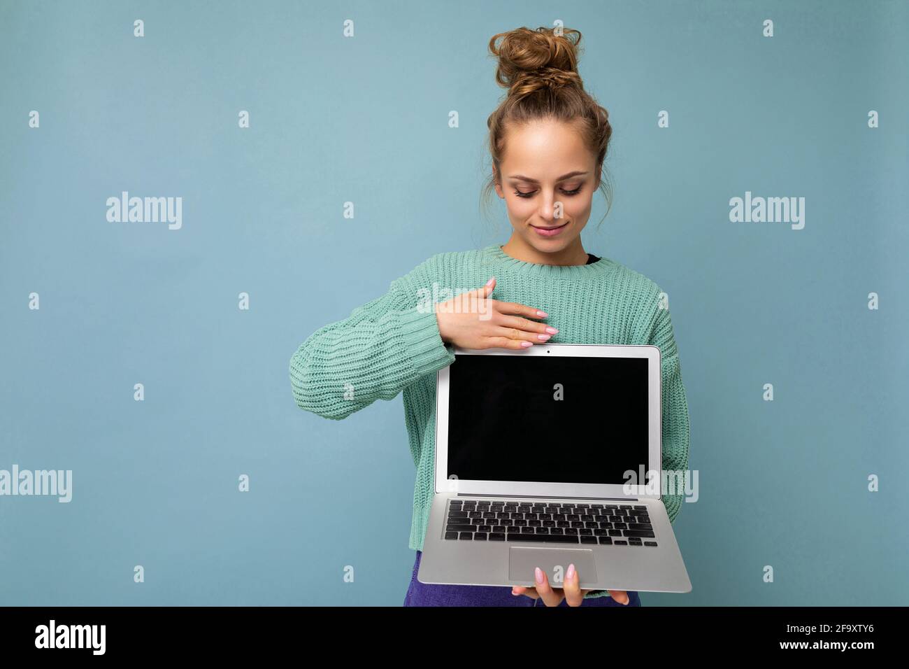 beautiful dark blond young woman with gathered curly hair looking down ...