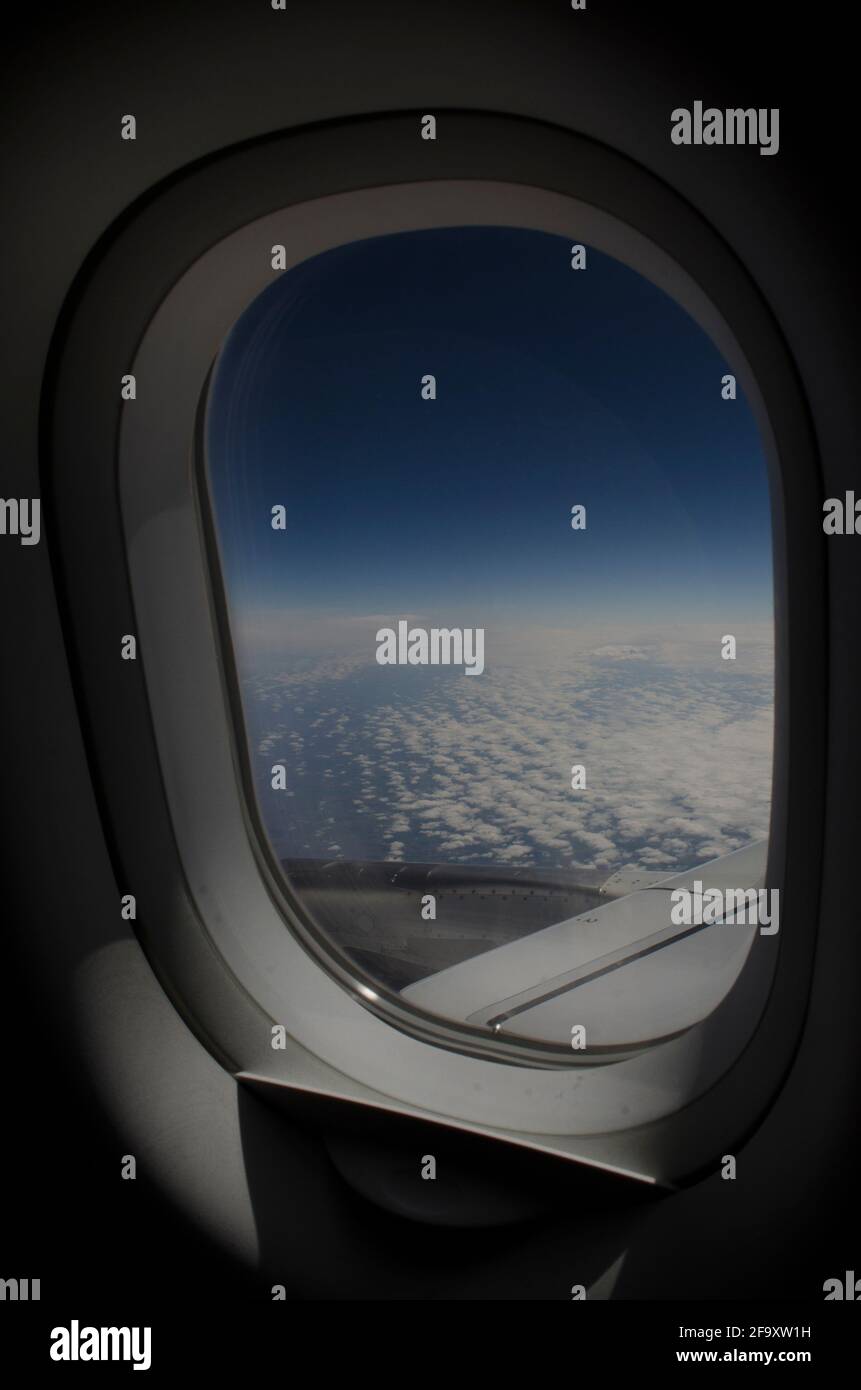 view from commercial airplane window, sky and clouds in the background ...