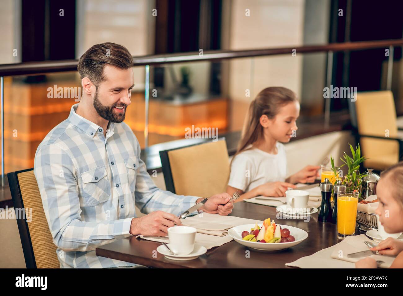 Happy family sitting at the table in the restaurant Stock Photo - Alamy