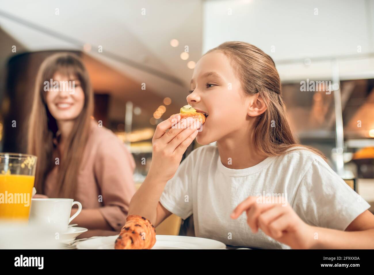 Cute girl biting a piece of sandwich Stock Photo - Alamy