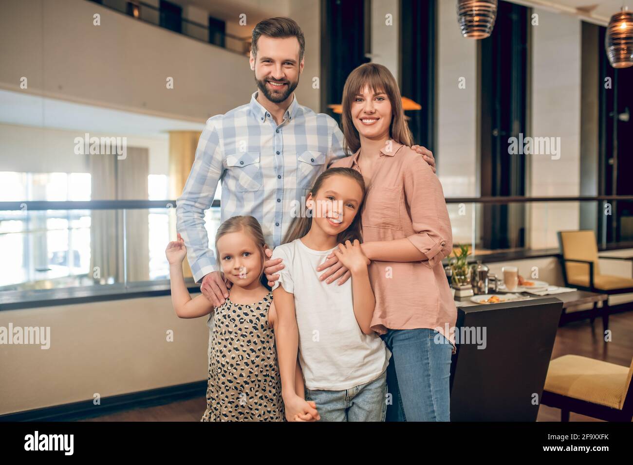 Young sweet family standing and looking happy Stock Photo - Alamy