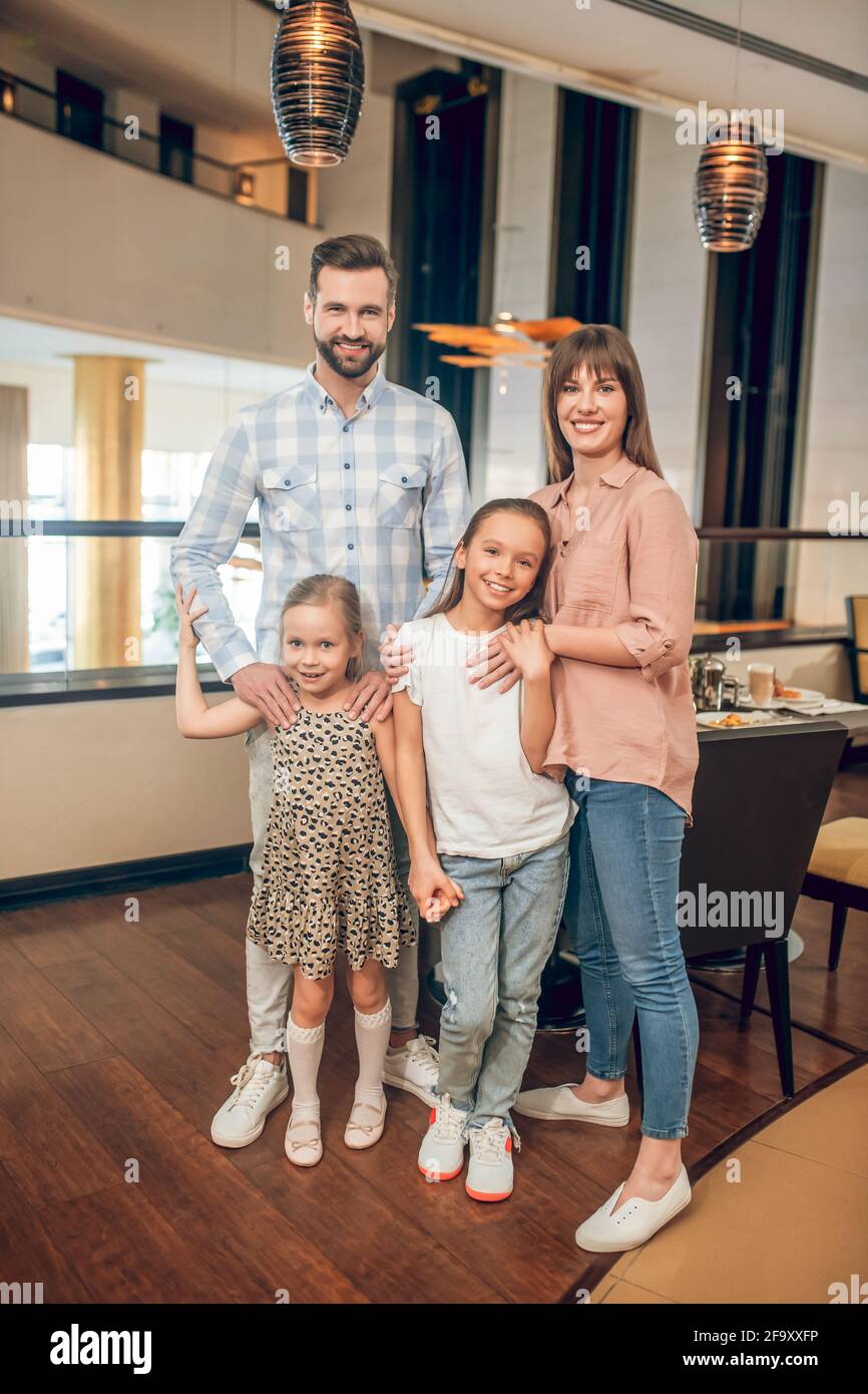 Young sweet family standing and looking happy Stock Photo - Alamy