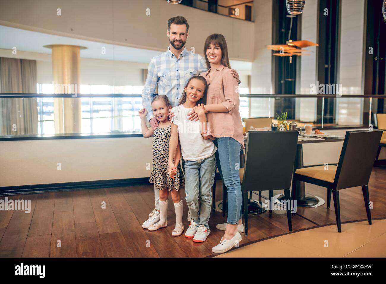 Young sweet family standing and looking happy Stock Photo - Alamy