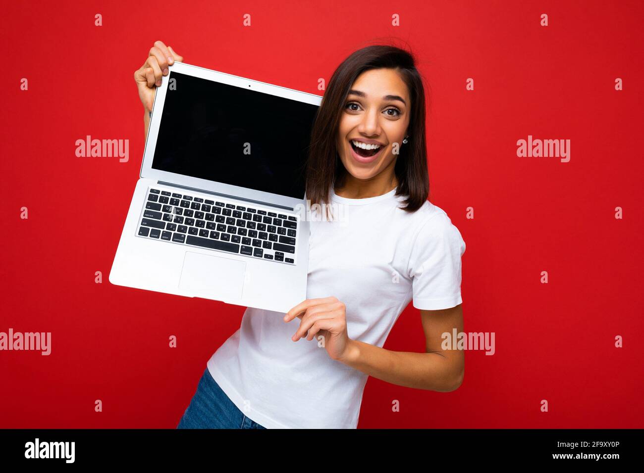 Photo of beautiful young woman holding computer laptop looking at ...