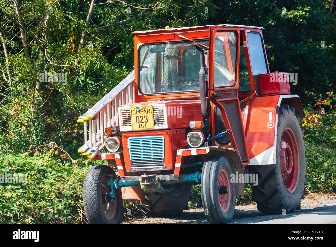 Red agricultural tractor on road in Bihor, Romania, 2020 Stock Photo ...