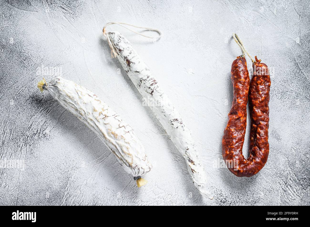 Spanish salami, fuet and chorizo sausages on a kitchen table. White ...