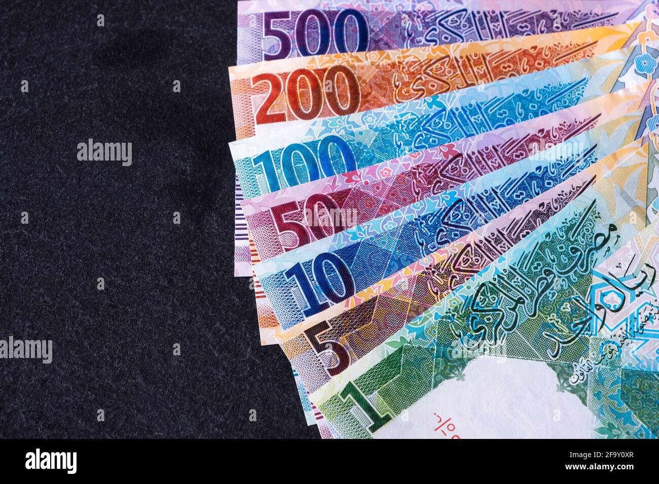 New Qatari Riyal banknotes on black background Stock Photo - Alamy