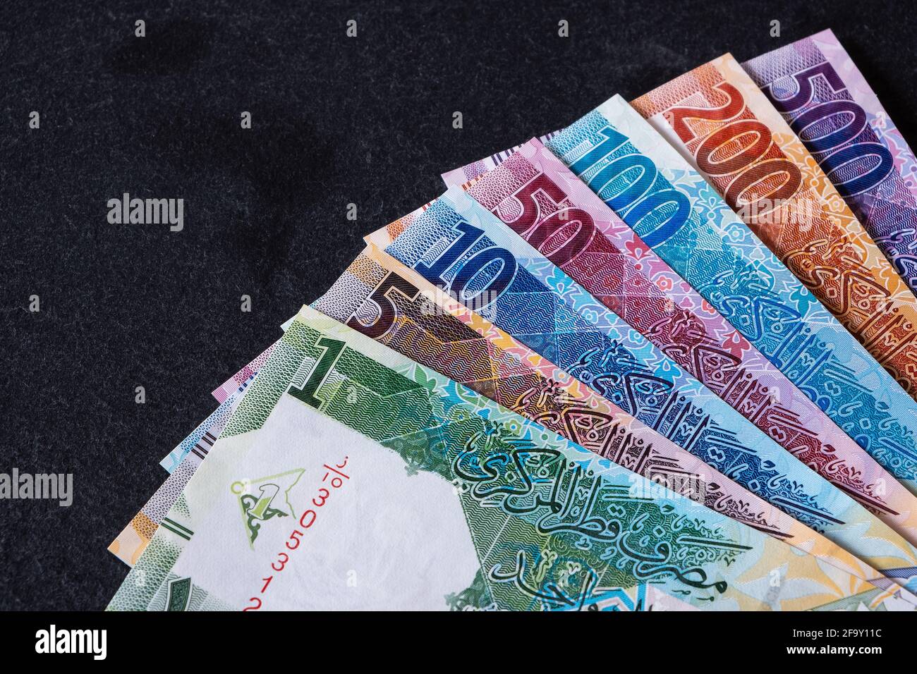 New Qatari Riyal banknotes on black background Stock Photo - Alamy