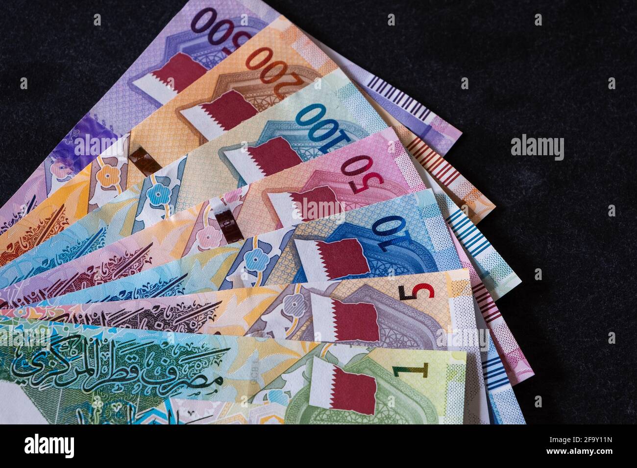 New Qatari Riyal banknotes on black background Stock Photo - Alamy