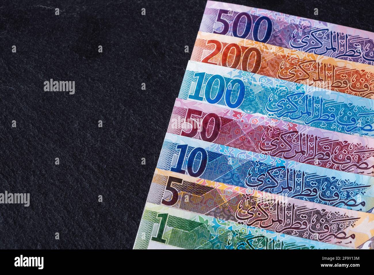 New Qatari Riyal banknotes on black background Stock Photo - Alamy
