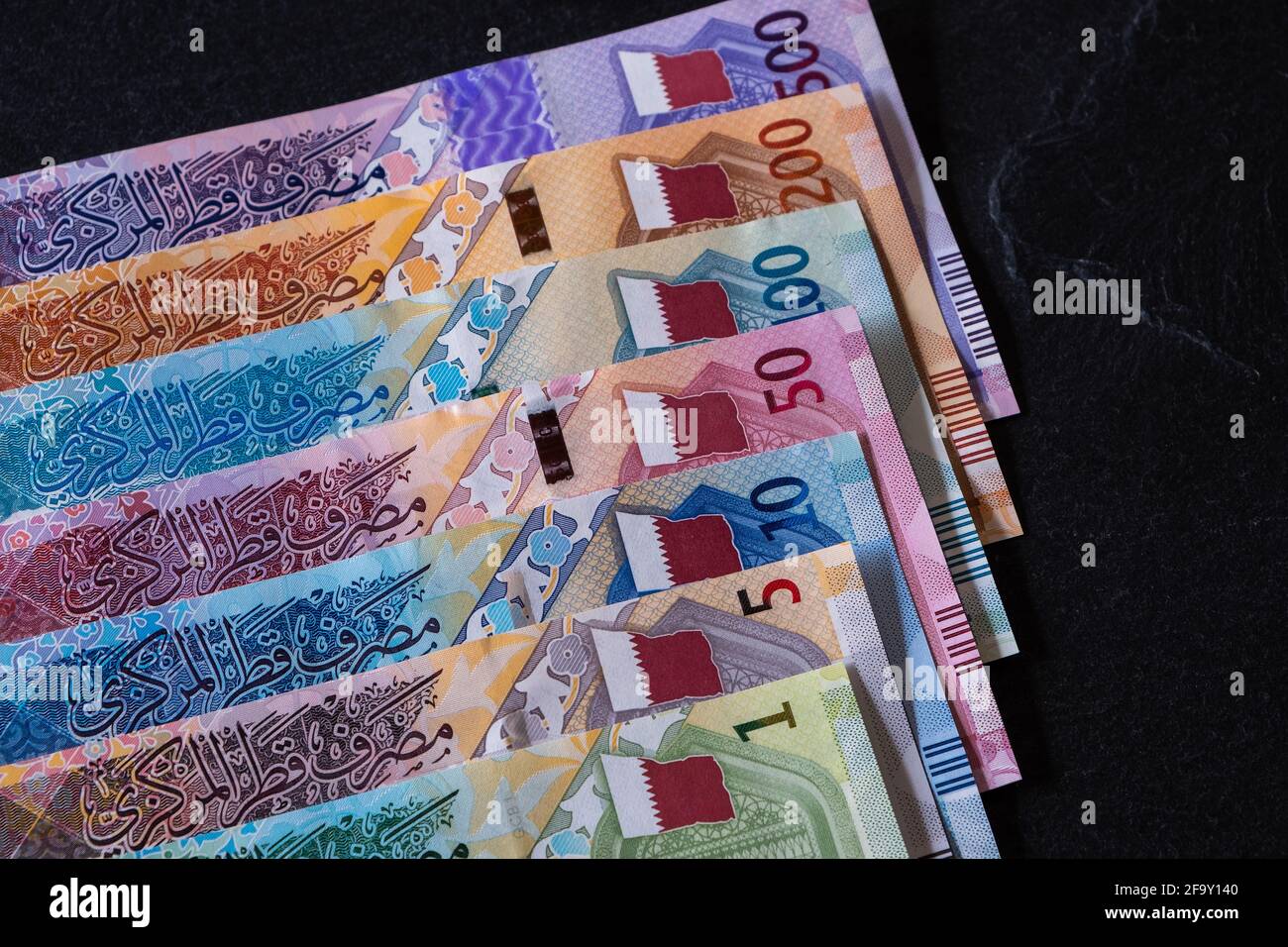 New Qatari Riyal banknotes on black background Stock Photo - Alamy
