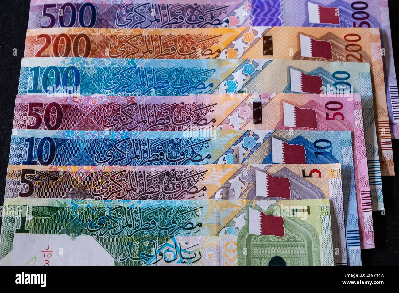 New Qatari Riyal banknotes on black background Stock Photo - Alamy