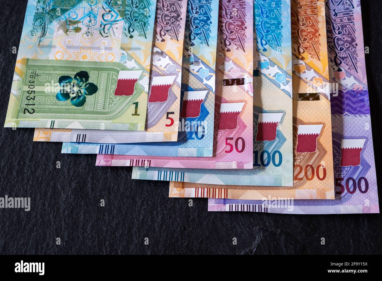 New Qatari Riyal banknotes on black background Stock Photo - Alamy