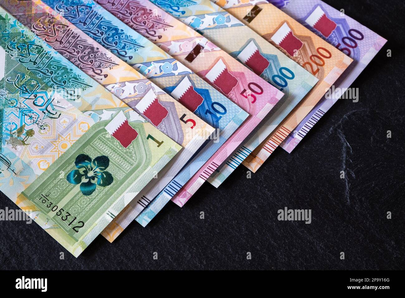 New Qatari Riyal banknotes on black background Stock Photo - Alamy