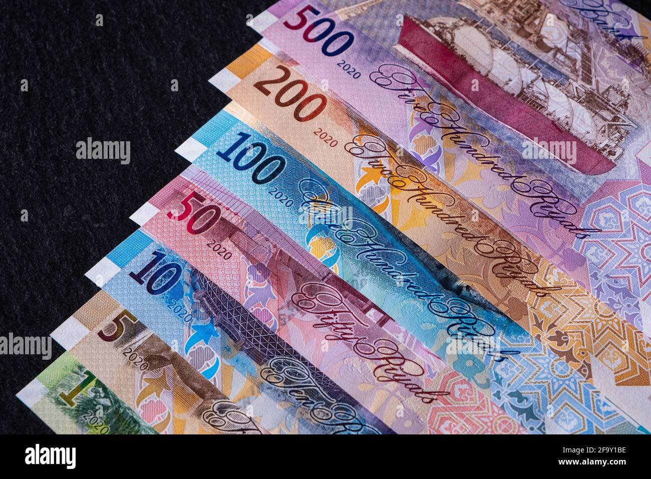 New Qatari Riyal banknotes on black background Stock Photo - Alamy